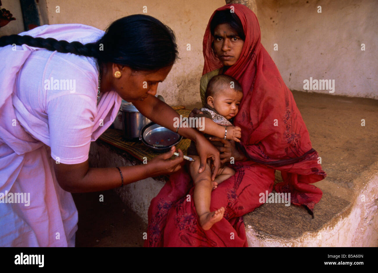 Child receiving vaccination from an aid project worker Bangalore India ...