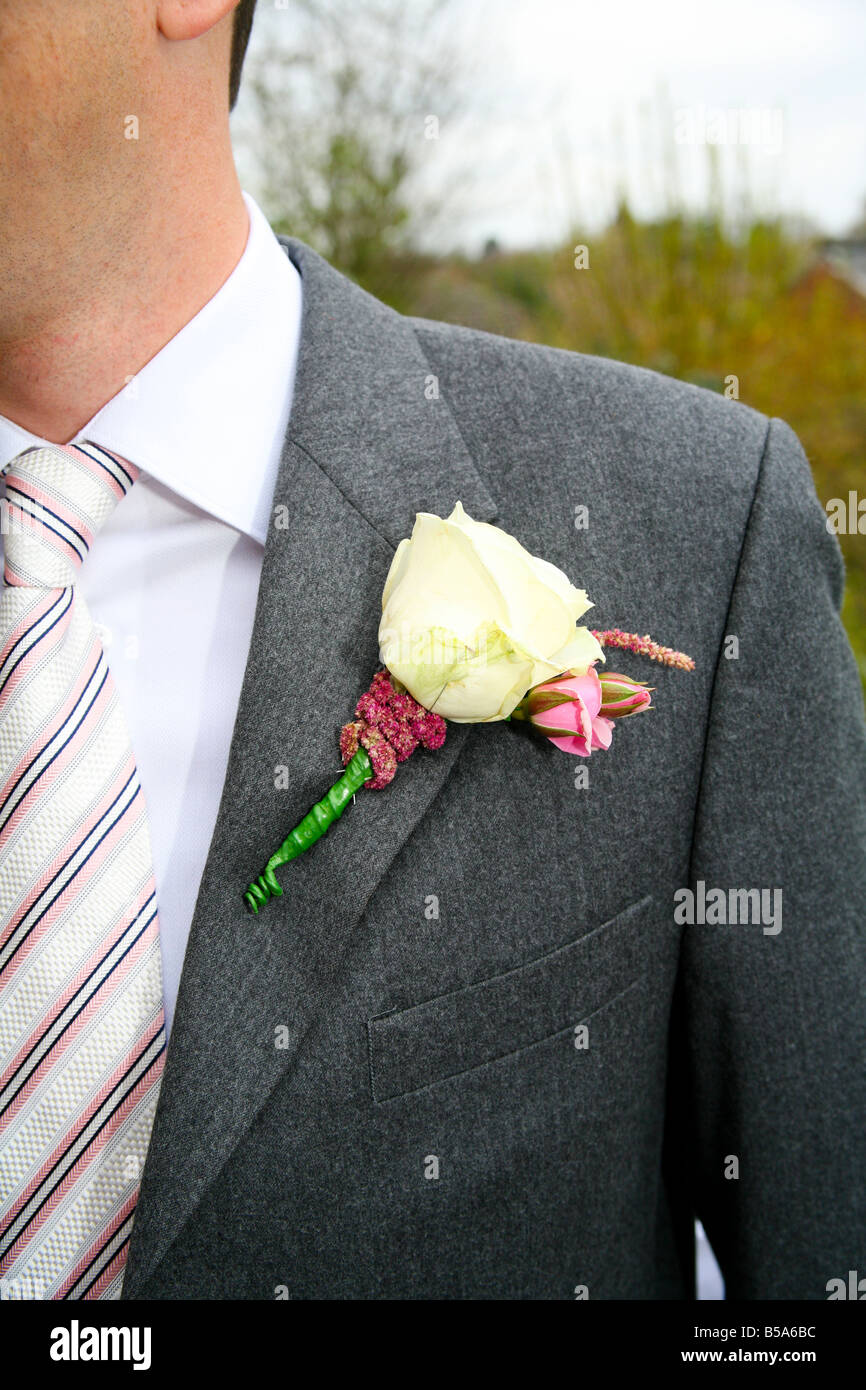 Groom wears a fresh rose on his lapel at a wedding Stock Photo - Alamy