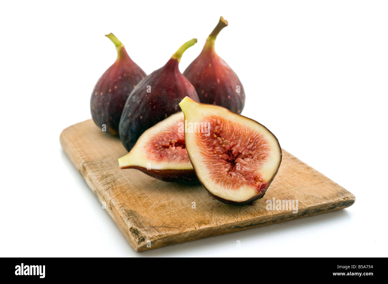 three whole figs and one sliced one isolated on white Stock Photo - Alamy