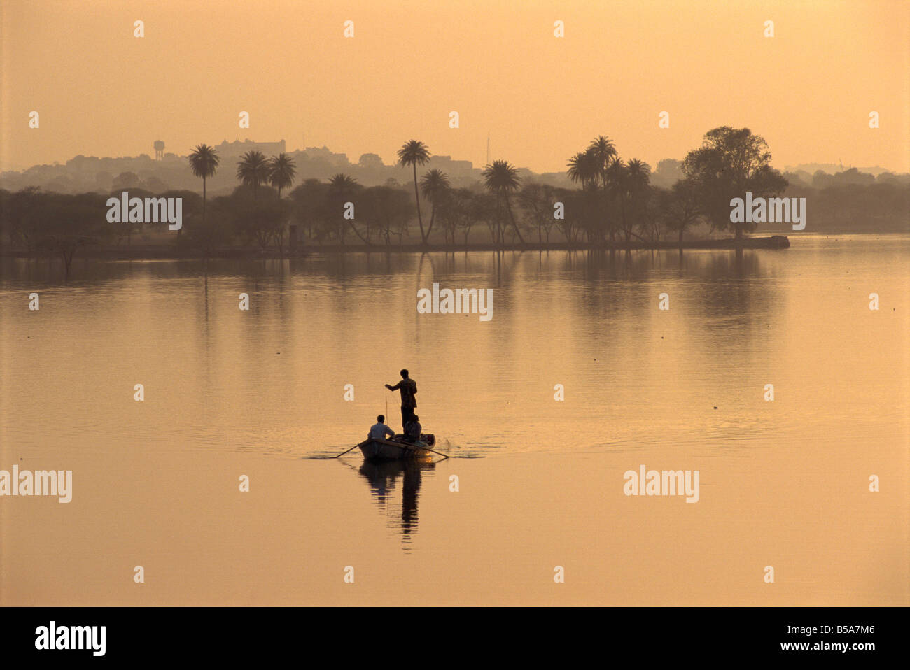 Men fishing in lake created by dam Deogarh Rajasthan state India Asia ...