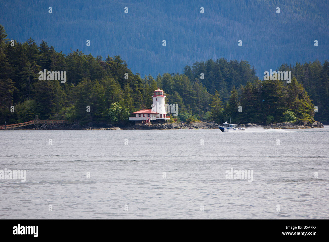 Lighthouse in front of evergreen covered mountains on island in Eastern ...