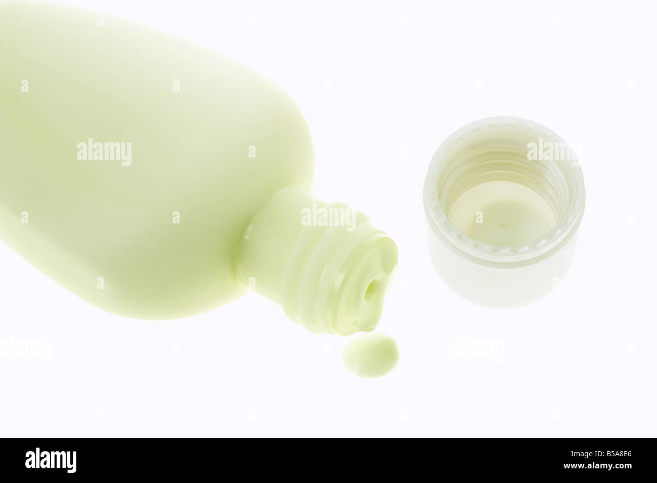 Dripping cosmetic lotion on white background Stock Photo - Alamy