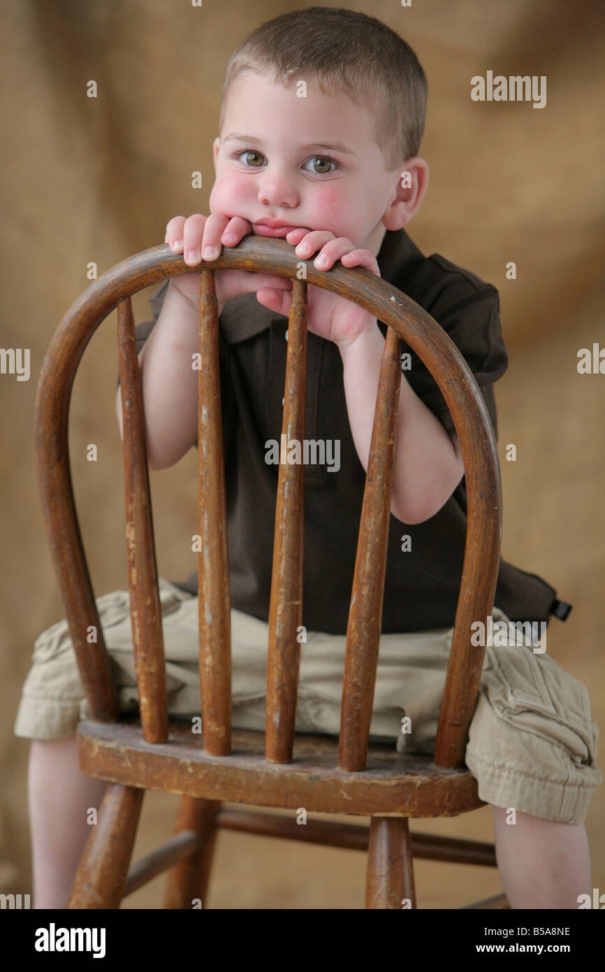 Portrait of young boy sitting on chair Stock Photo - Alamy