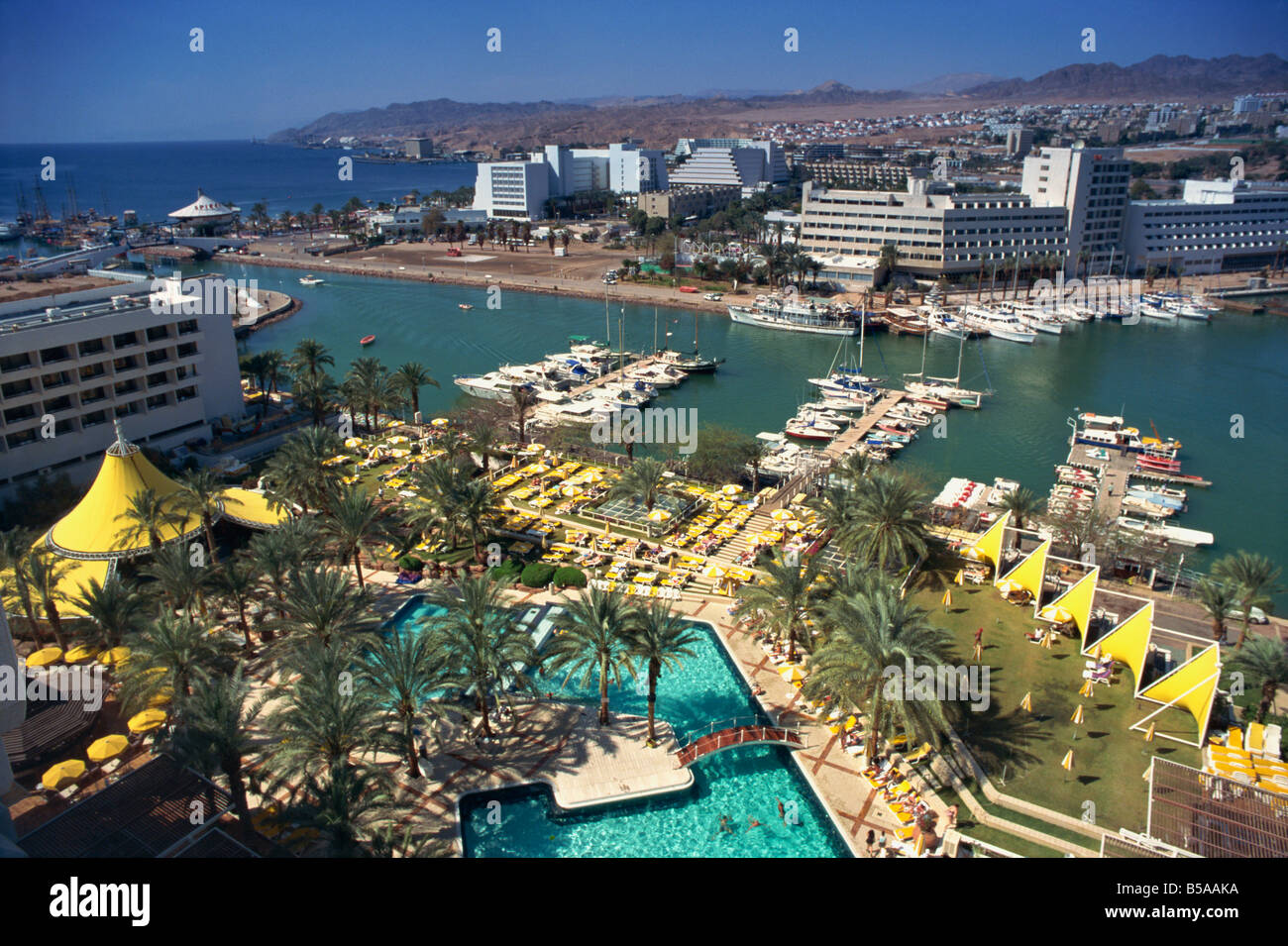 Aerial view over swimming pool, palm trees and the marina at Eilat ...