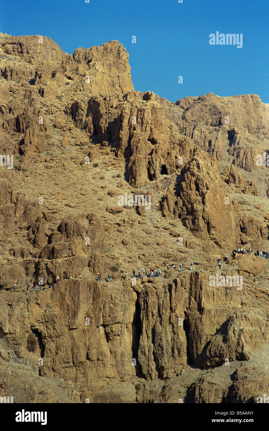 Tourists walking through rocky landscape in Wadi Rumdan, south of Judea ...