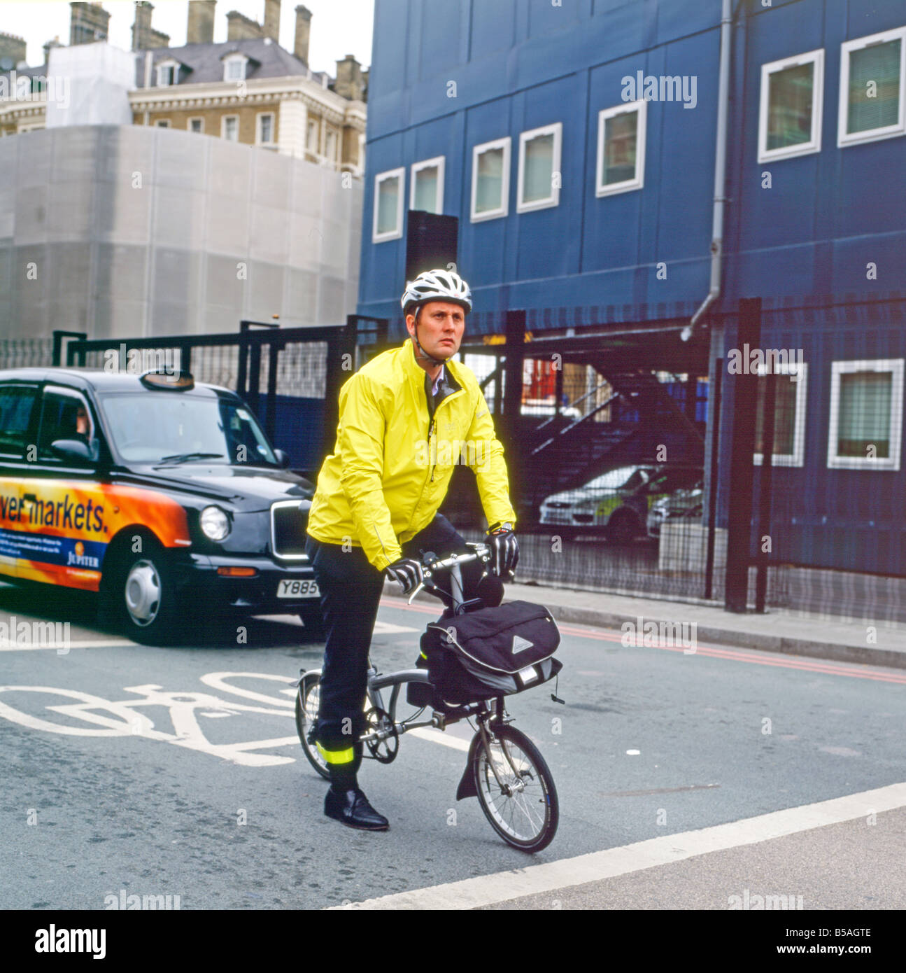 A businessman office worker cyclist cycling to work on a Brompton bike ...