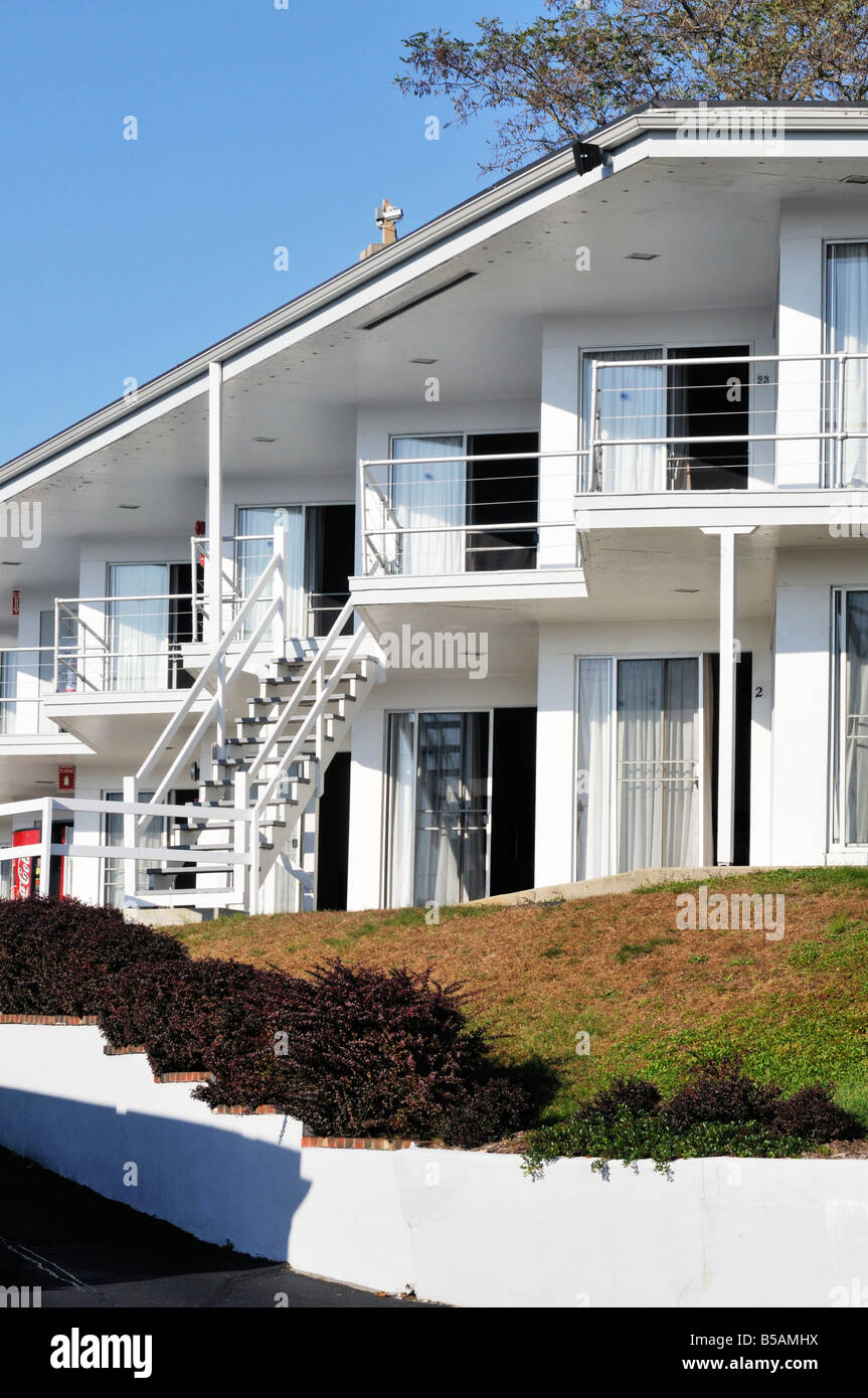White motel building with balconies, stairs and sliding glass doors in ...