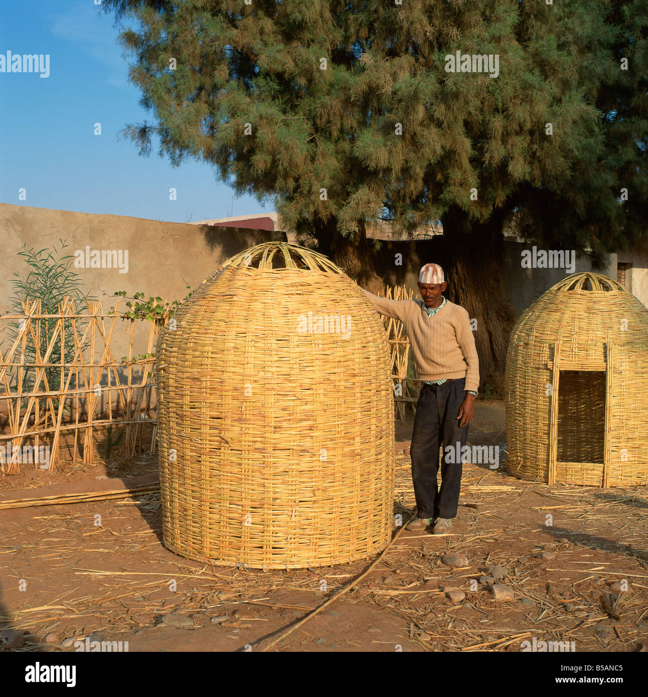 Portrait of man beside woven bamboo shower cubicle Morocco Africa T ...