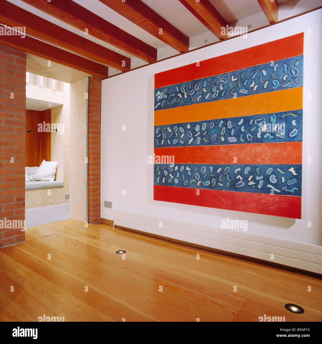 Large vibrant abstract painting and wooden flooring with uplighting in ...
