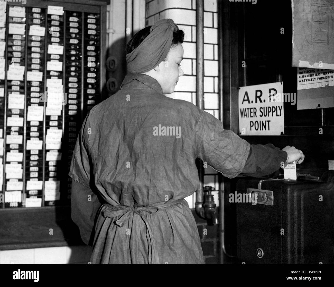 A worker clocking in for her shift at an arms factory in England during ...