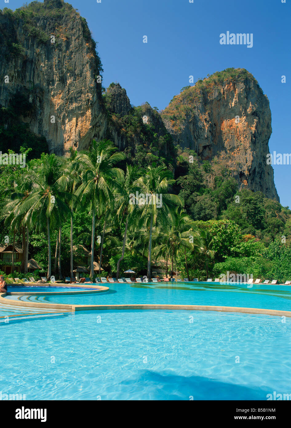 Pool at the Dusit Rayavadee Hotel with limestone rock formation behind ...