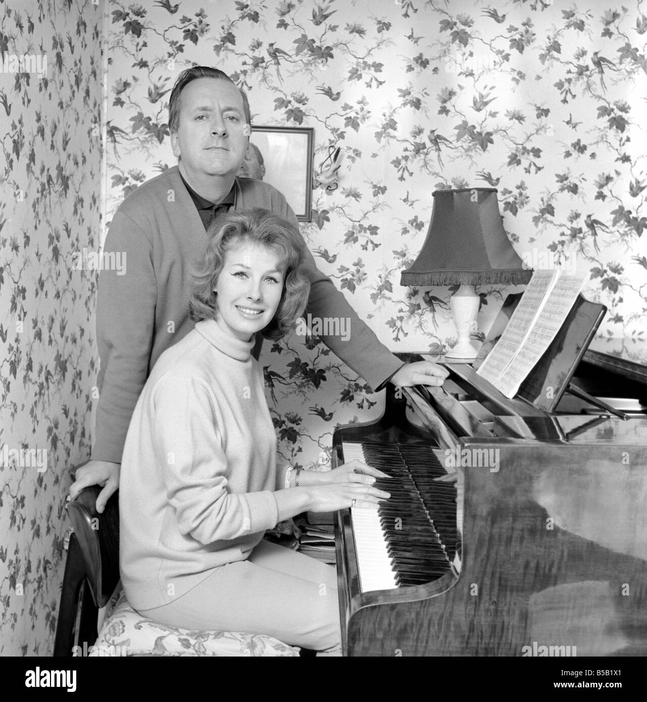 TV actor Hugh Lloyd seen here at home with his wife at the piano. 1960 ...