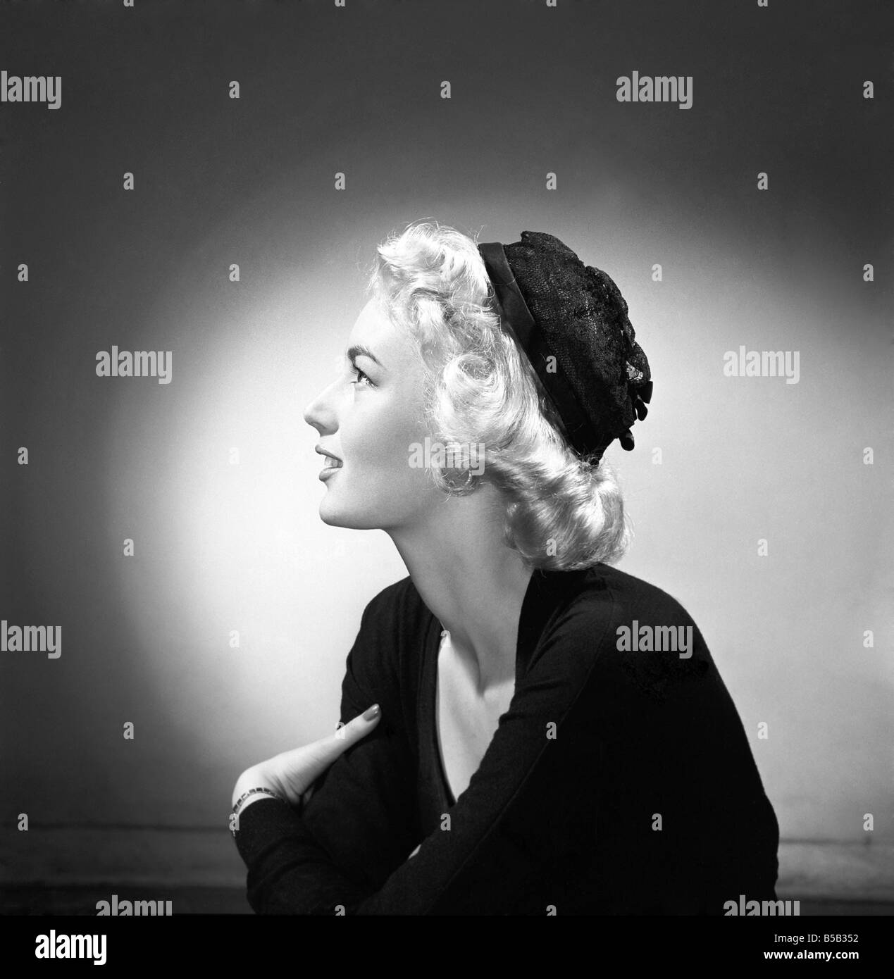 Woman modelling the latest 1956 hat fashions in the Reveille studios ...