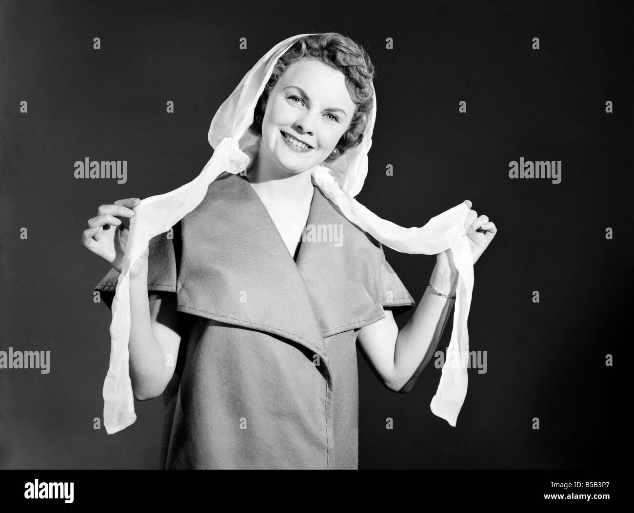Model Maureen Denham putting on head scarf. July 1956 Stock Photo - Alamy