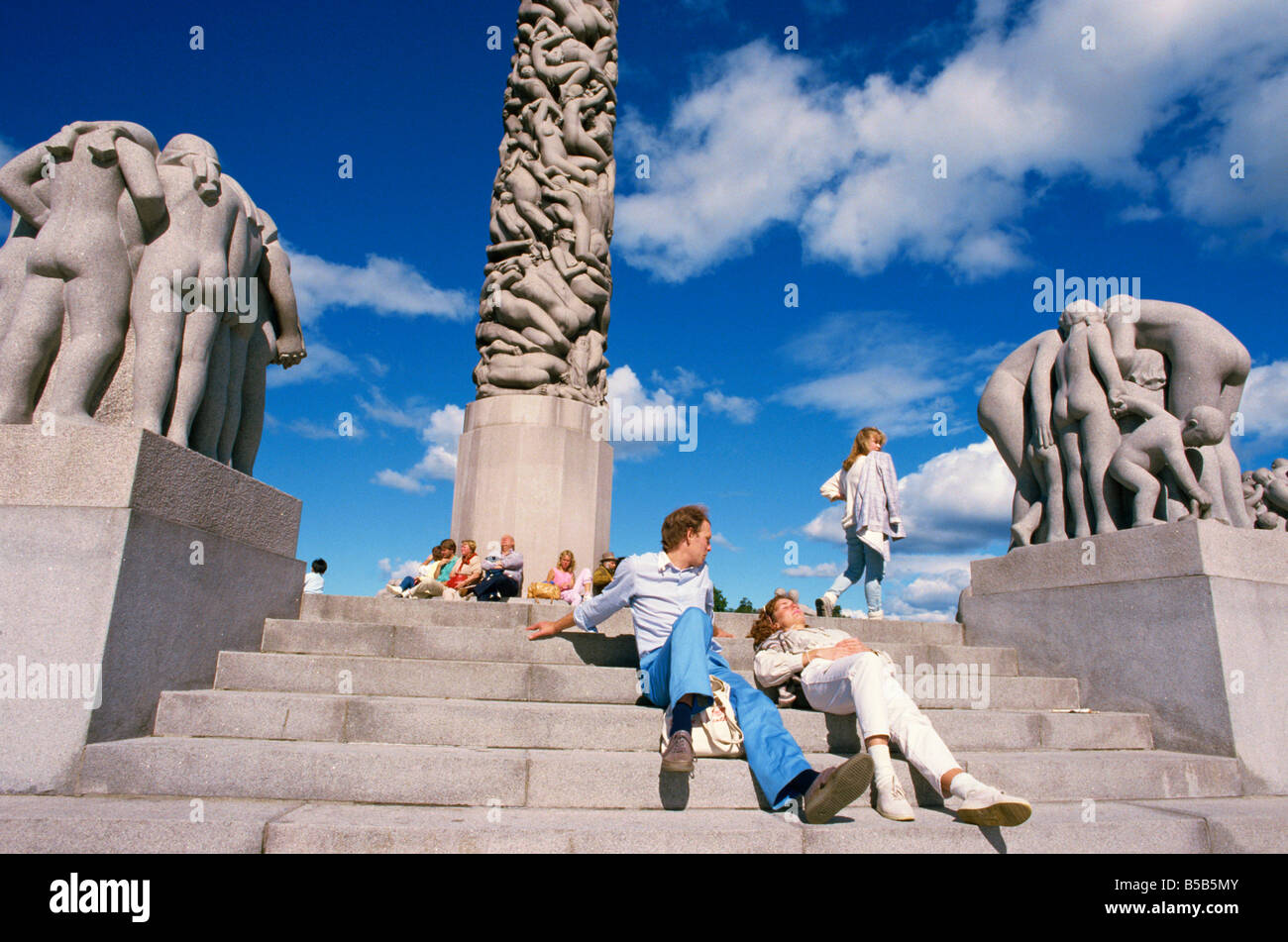 People relaxing on steps before sculptures on the central stele in ...