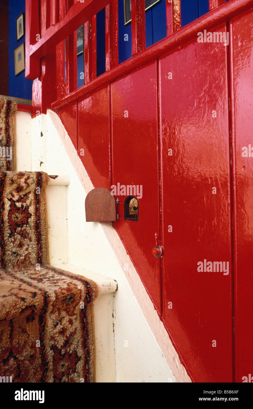 Close-up of miniature door in red paneled wall of cottage stairs Stock ...