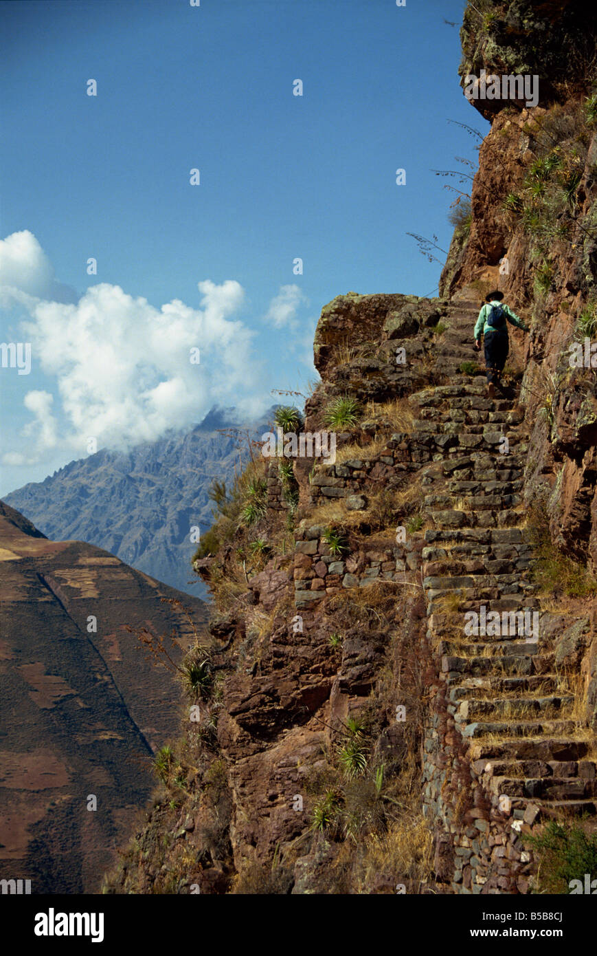 A walker climbs the steps on a narrow path along the edge of a cliff at ...