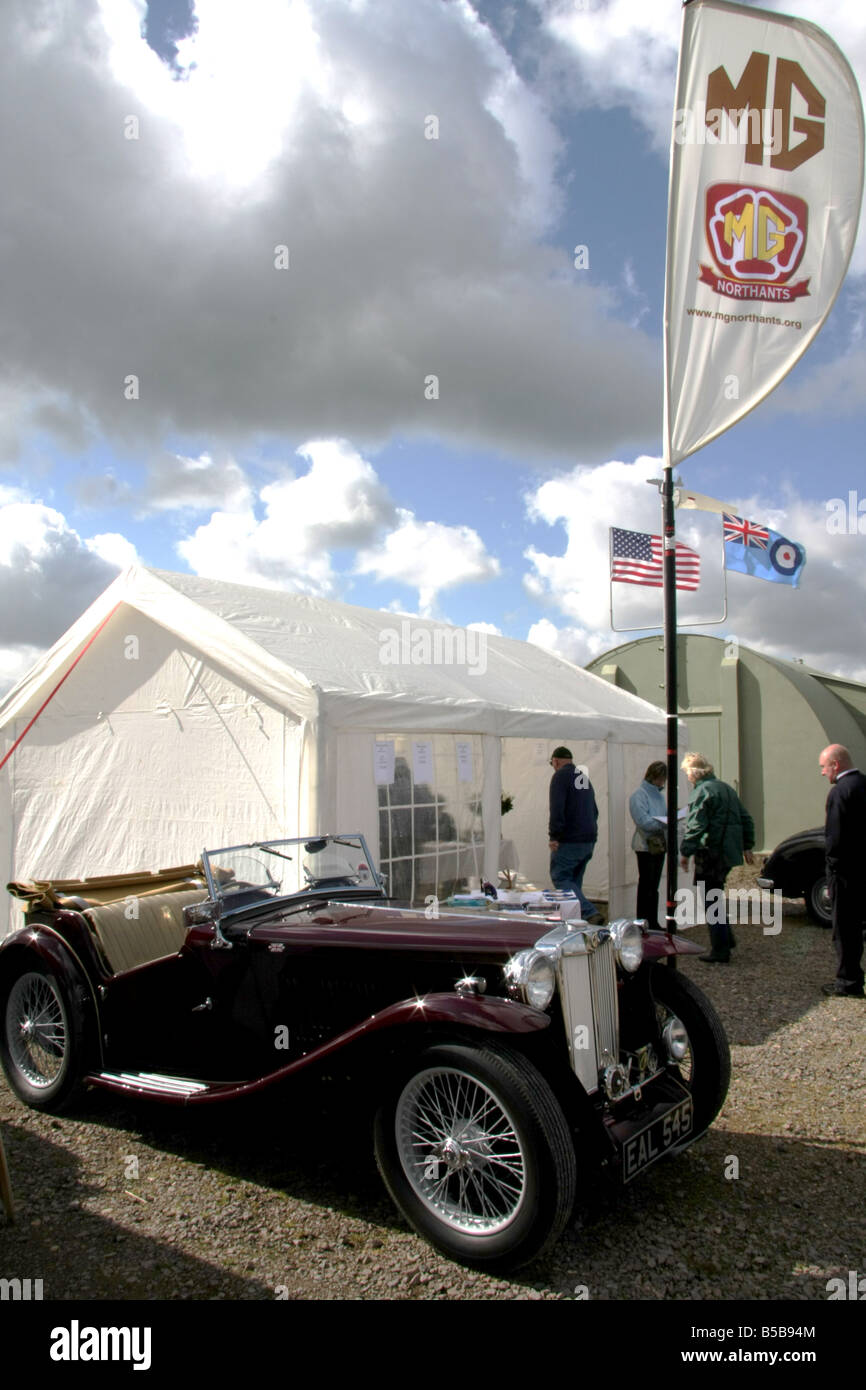 A classic MG car with a marquee and flag showing the MG Logo in the ...