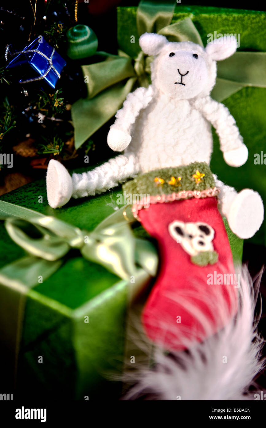 White toy sheep sitting with presents and stocking by the decorated ...