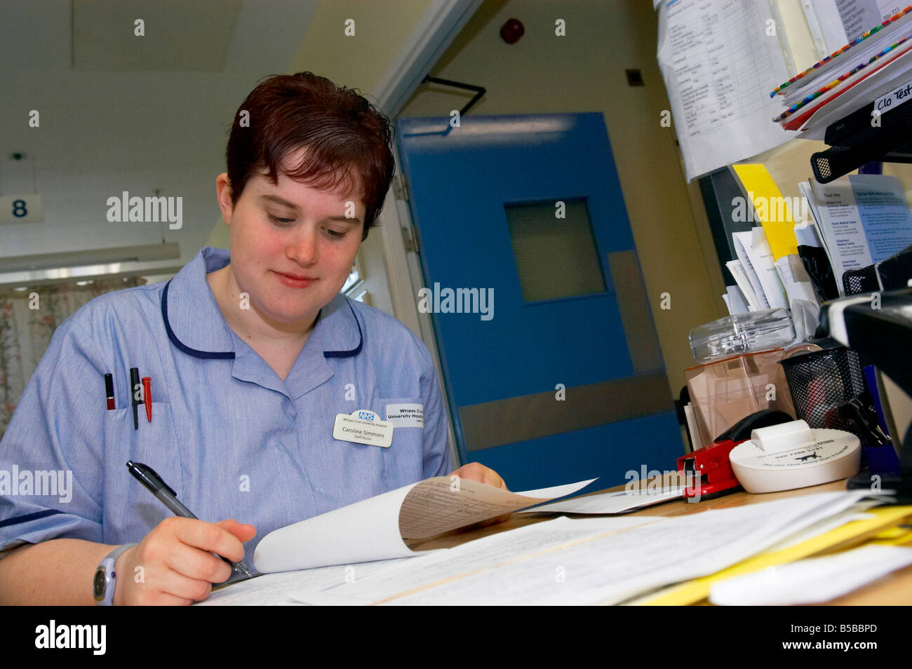 A young staff nurse at her desk Stock Photo - Alamy