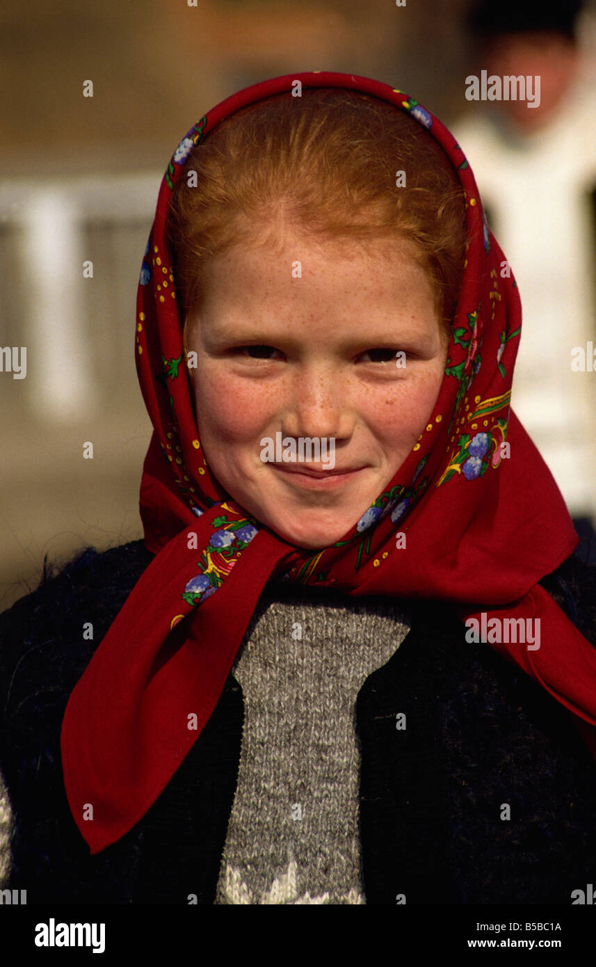 Portrait of a young girl with red hair wearing a red head scarf in ...