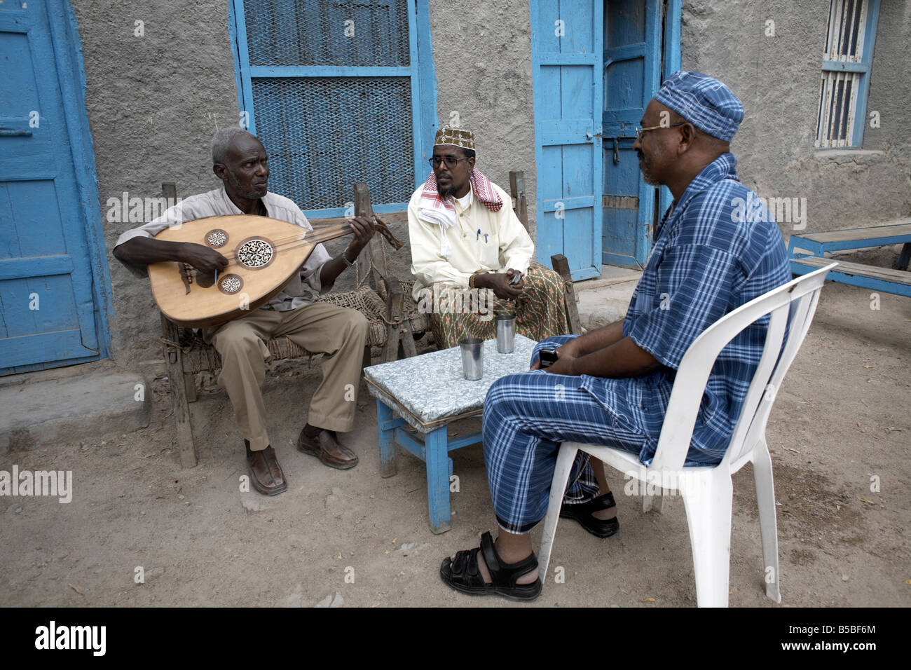Locals relax with some traditional music, on the streets of Berbera ...