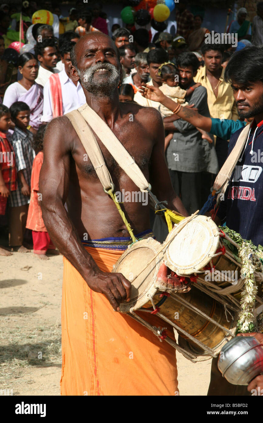 A man plays the drums in a rural Tamil Nadu village. He does this in a ...