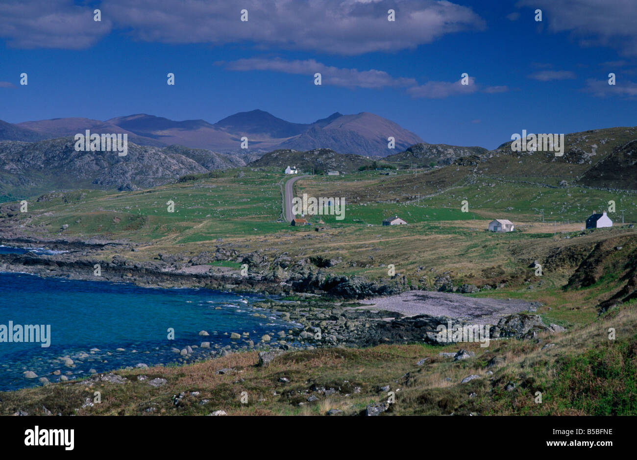 Coast Shingle beach inlet Road along shore Leading into hills mountains ...