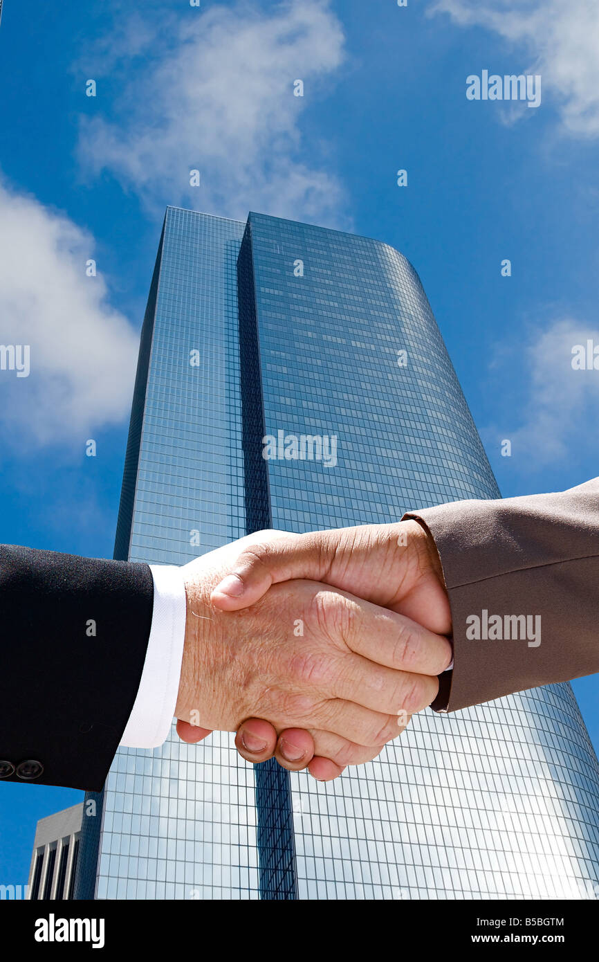 Businessman handshake against the towering skyscrapers of downtown ...