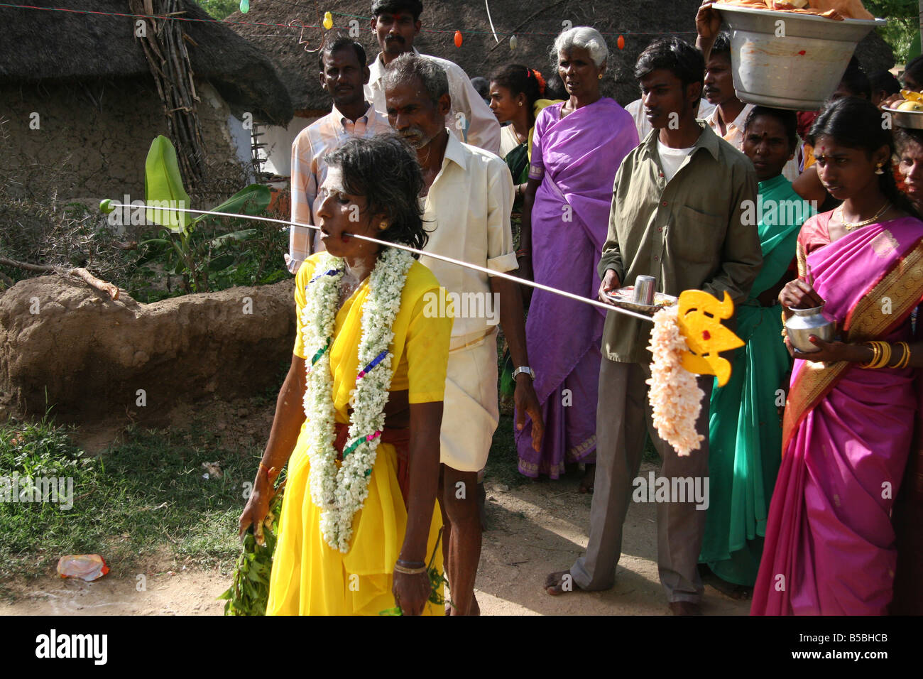 Villagers look on as a woman walks through a village in rural Tamil ...