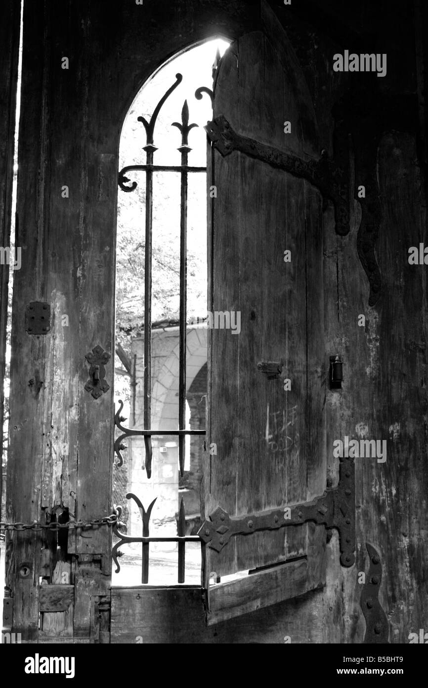 Old window shutter semi-open / half-closed. Light came int the open ...