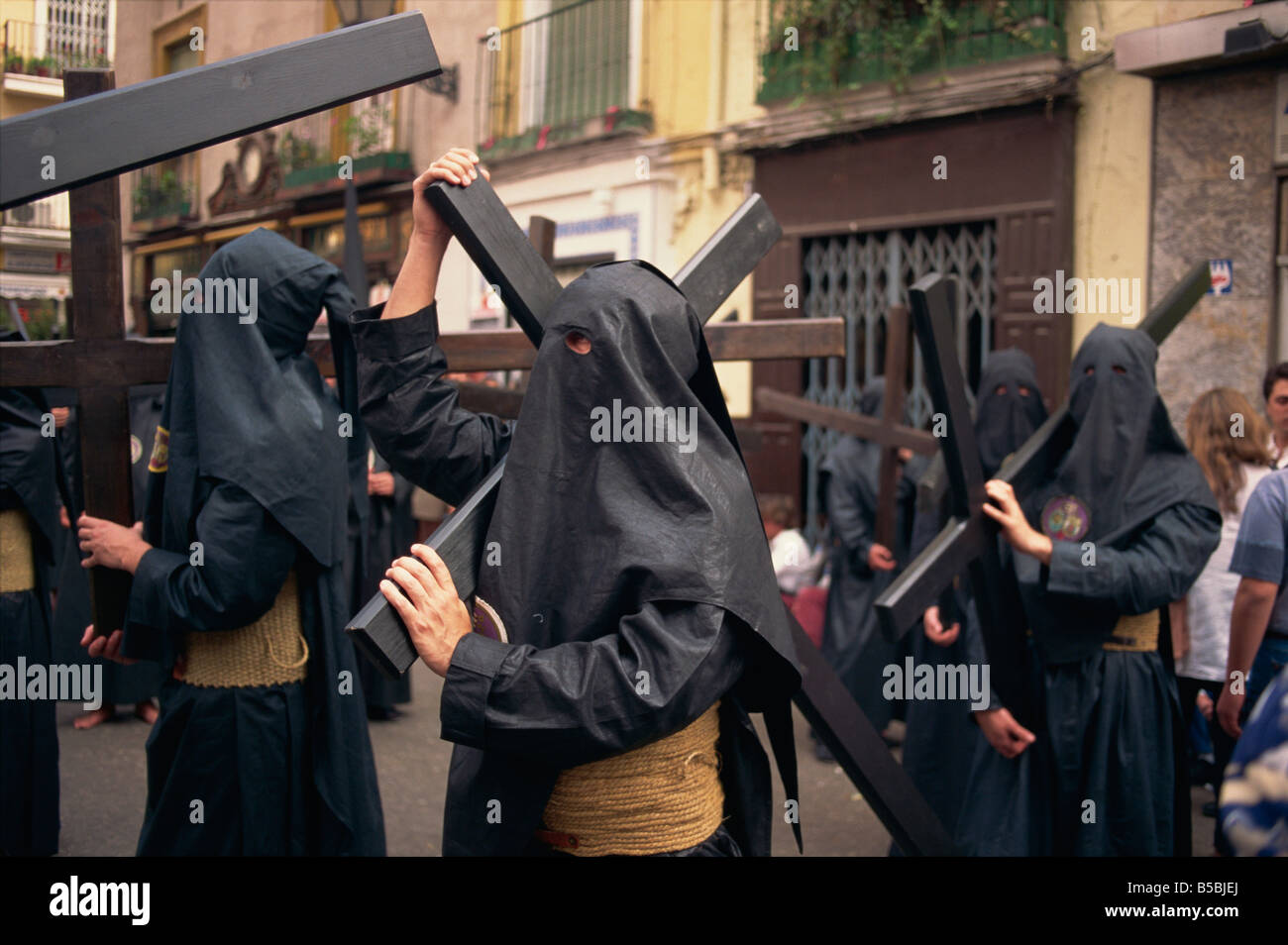 Penitents bearing crosses in procession Holy Week Semana Santa Seville ...