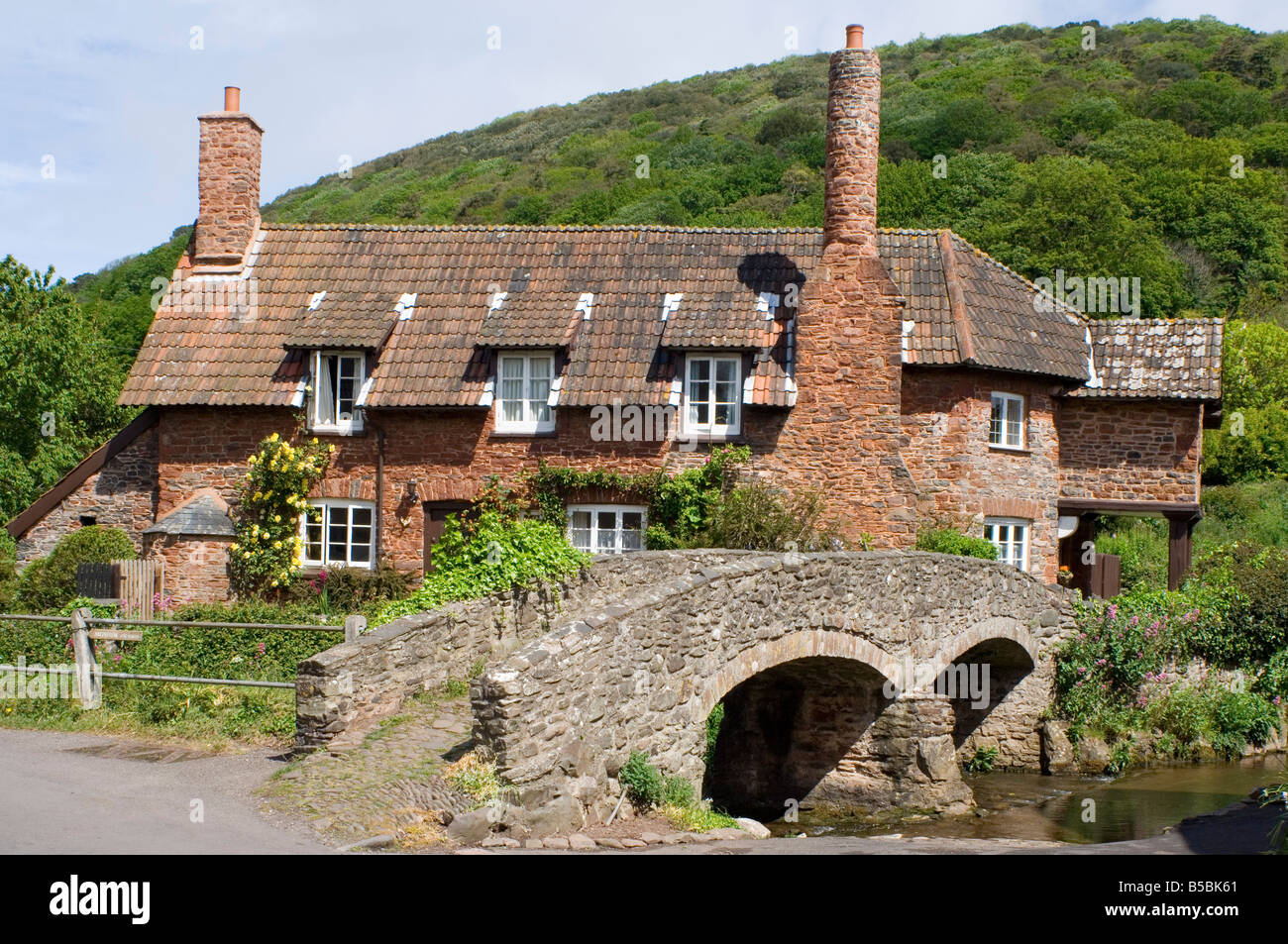 An old stone house with round chimney and stone bridge in Allerford ...