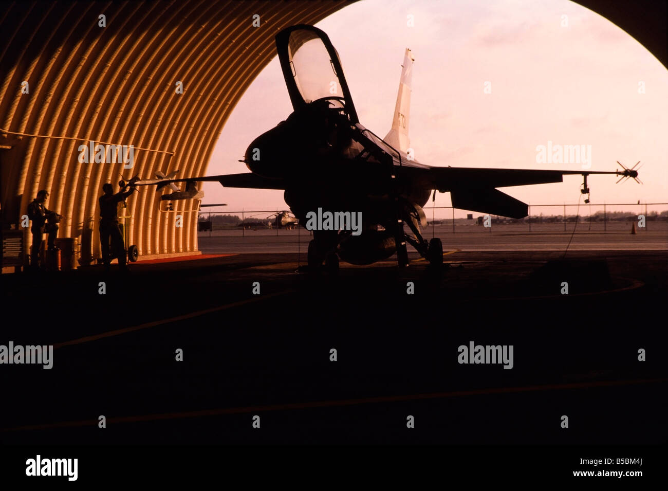 US Air Force F-16 fighter plane with crew, on ground loading missles ...