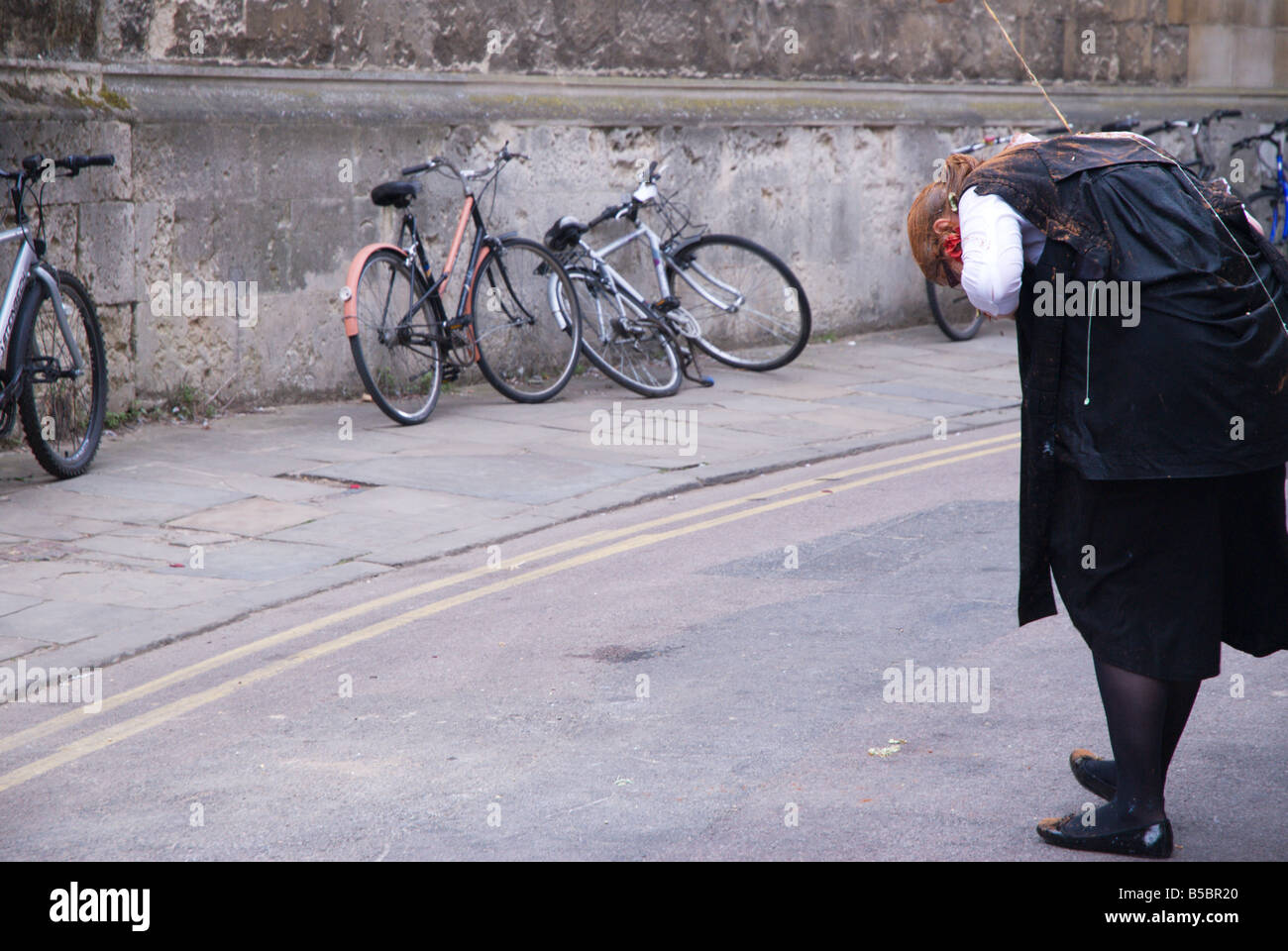 Oxford University student in subfusc covered in food and holding the ...