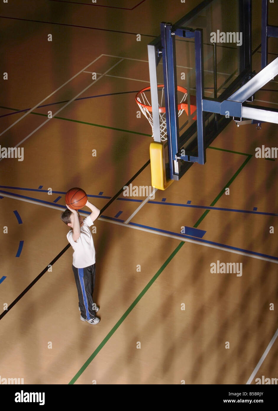Boy aiming ball at basketball net Stock Photo - Alamy