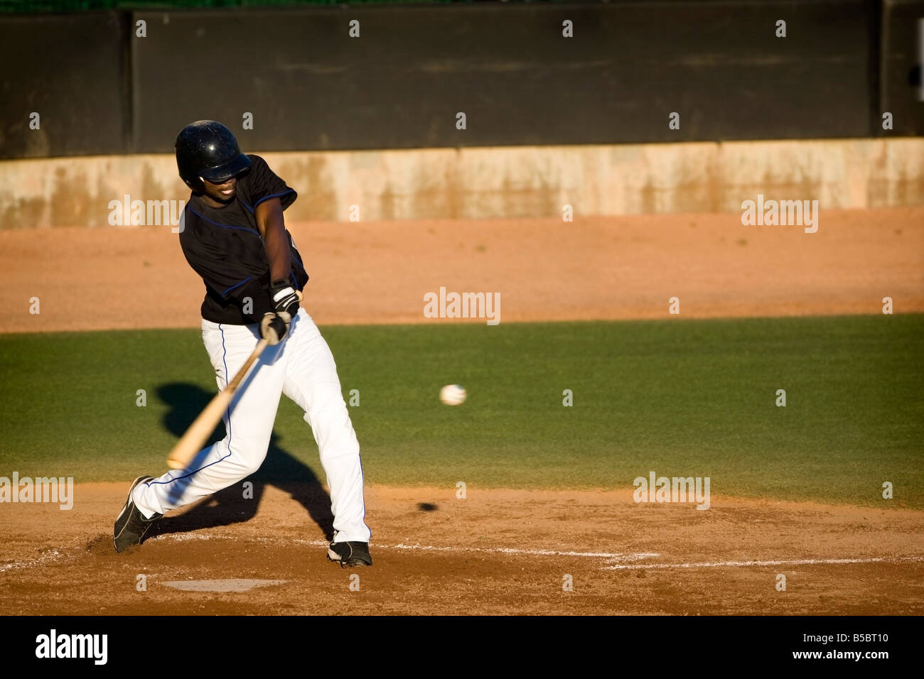Baseball player swinging his bat Stock Photo - Alamy