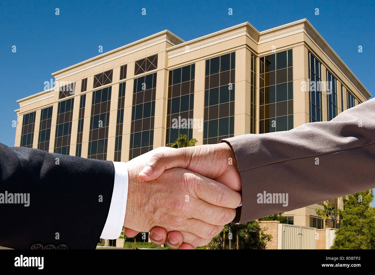 Businessman handshake against the towering skyscrapers of downtown ...