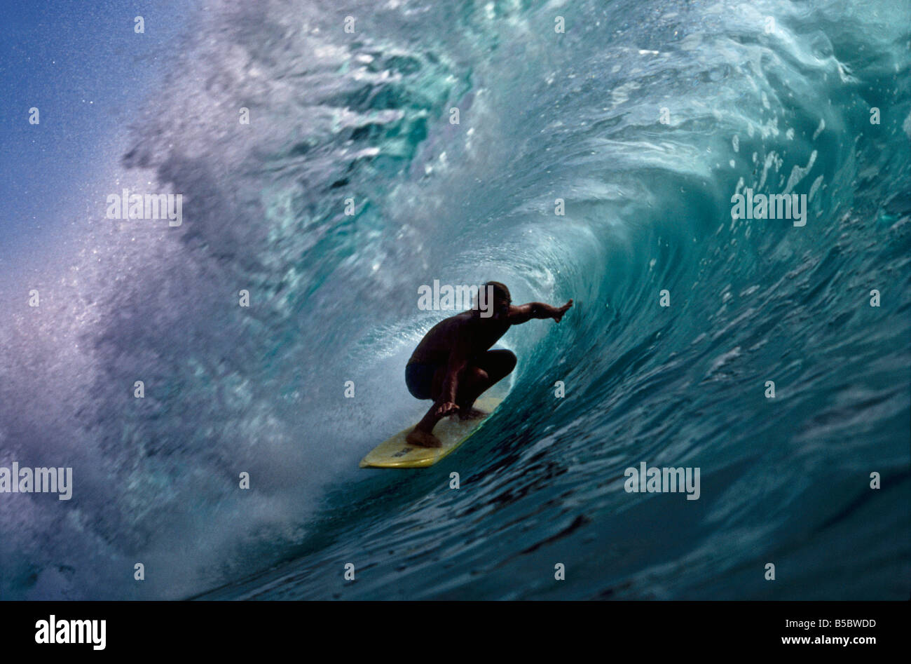 Surfer Peter McCabe riding the barell of a wave in Padang Padang Bali ...