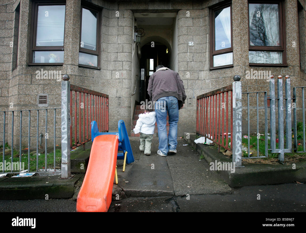 a child and her father on a poverty stricken estate in Maryhill Glasgow ...