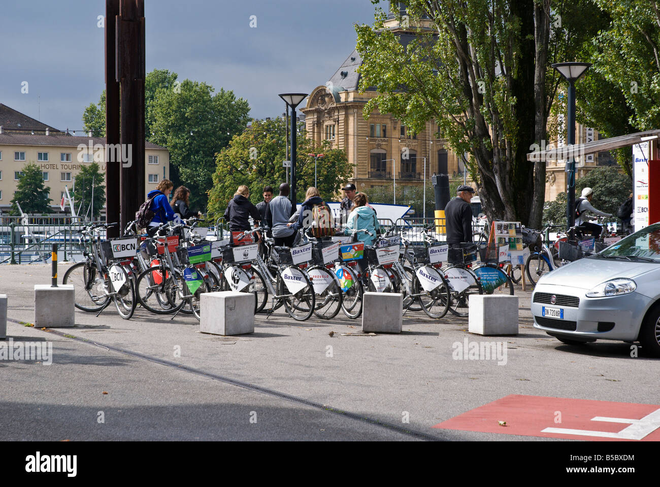 A group of men and woman are renting free bicycles to go for a group ...