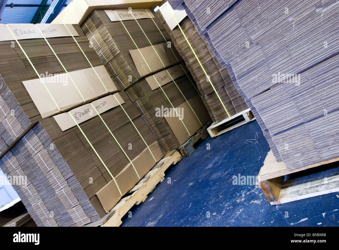 New flat cardboard boxes bundled together on top of wooden pallets ...