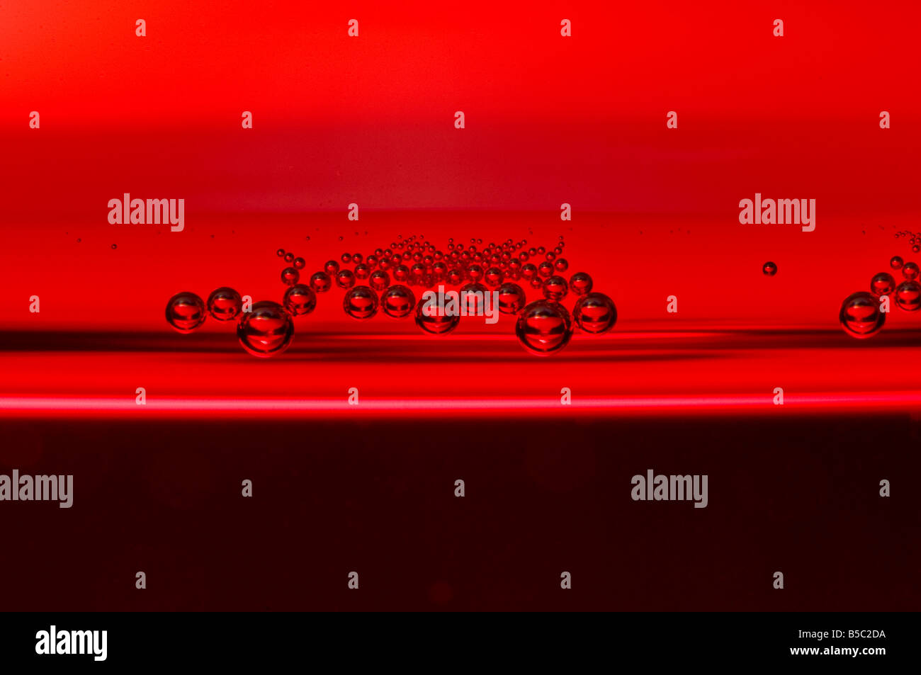 Bubbles in Red coloured liquid Stock Photo - Alamy