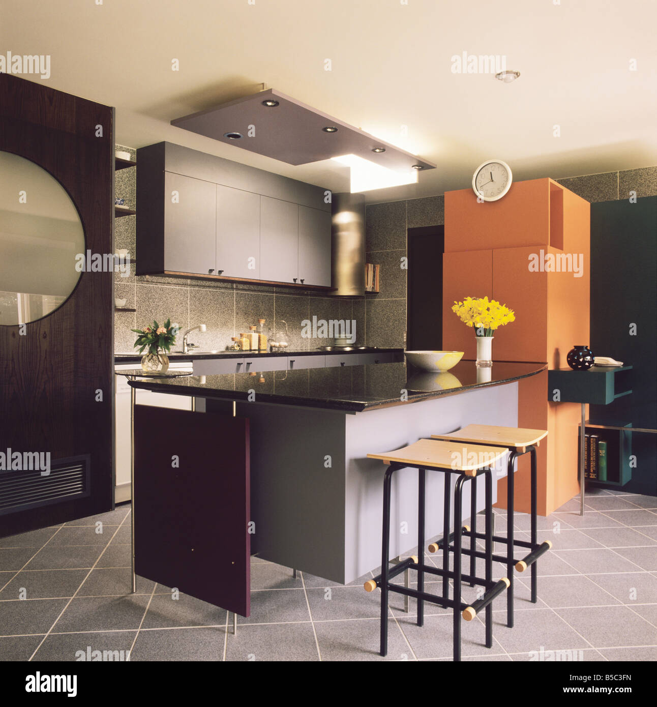 Metal stools at breakfast bar on black & white island unit in modern ...