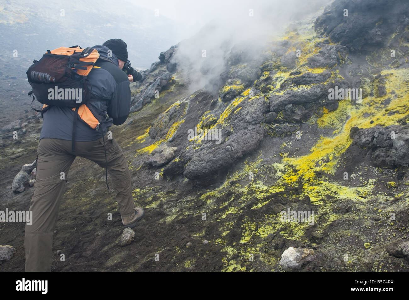 Volcano climber photographing sulphur deposits at a fumarole inside Mt ...