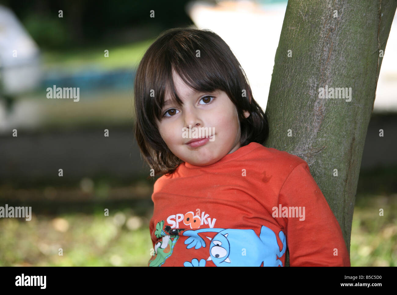 Kid leaning against tree hi-res stock photography and images - Alamy
