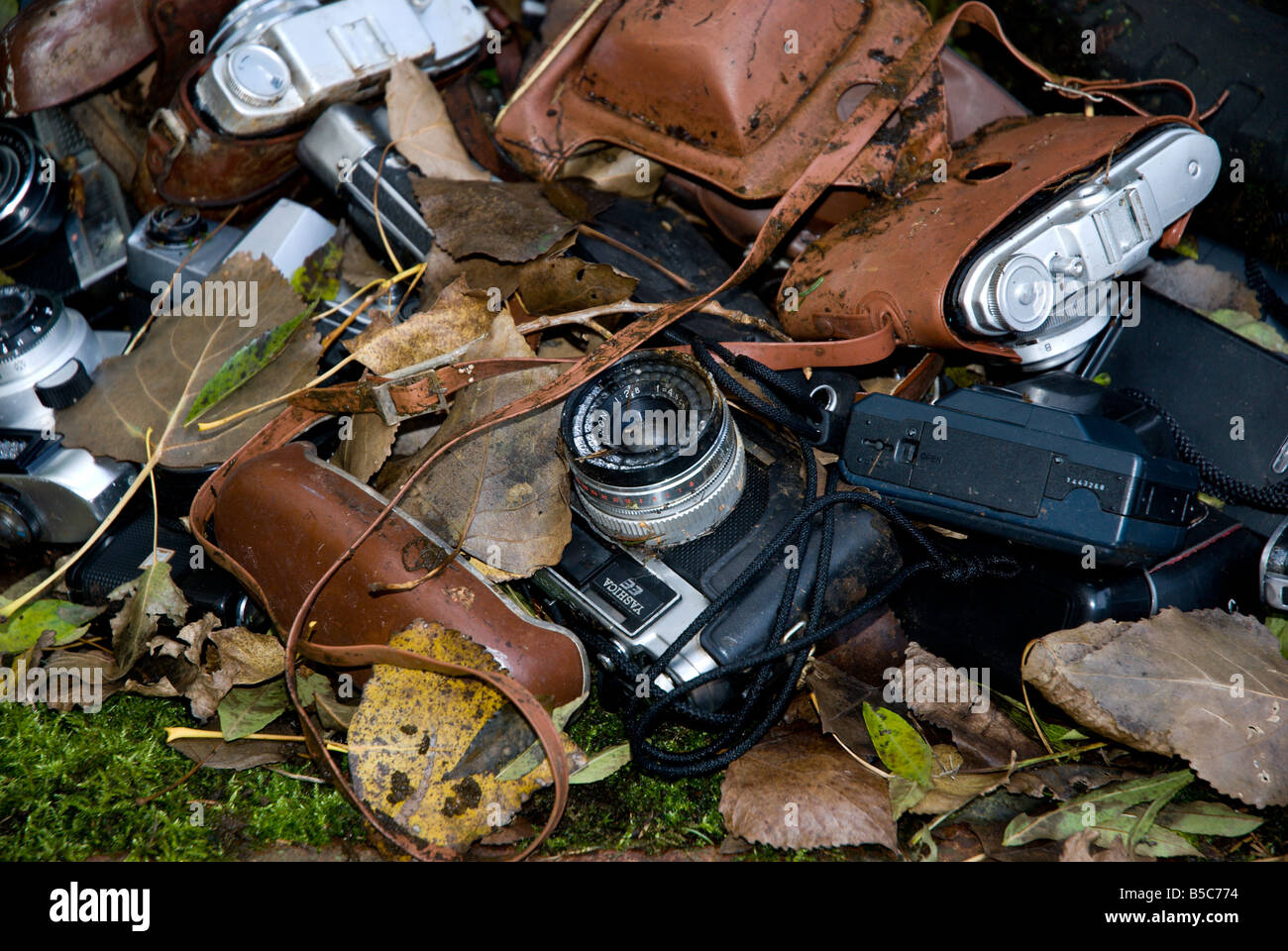 Old cameras and lens sit on top of a car at An old morris sits grinning ...