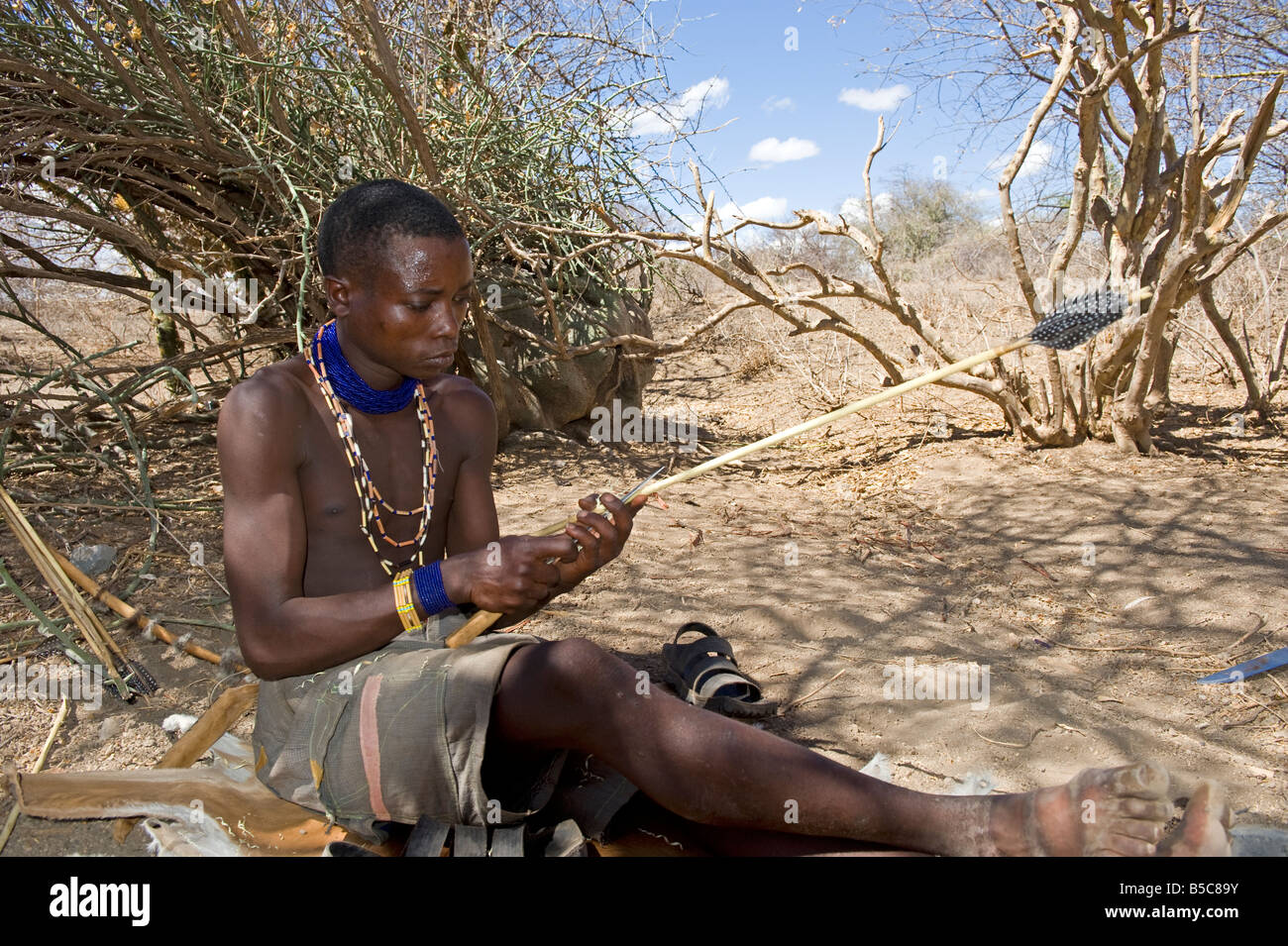 A member of the Hadza tribe examines an arrow before going to hunt Lake ...