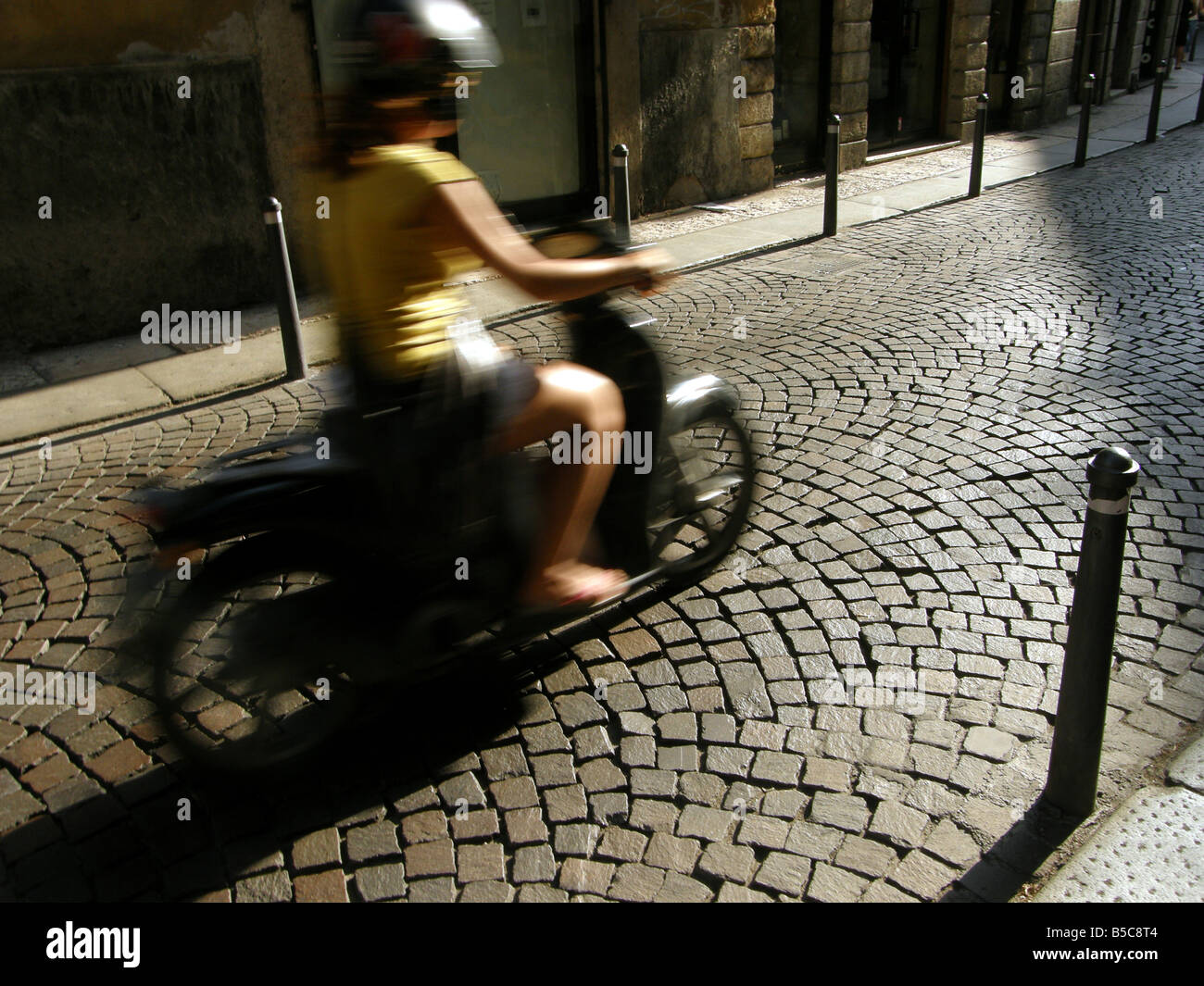 woman driving moped speeding along cobbles in Verona Italy Stock Photo ...