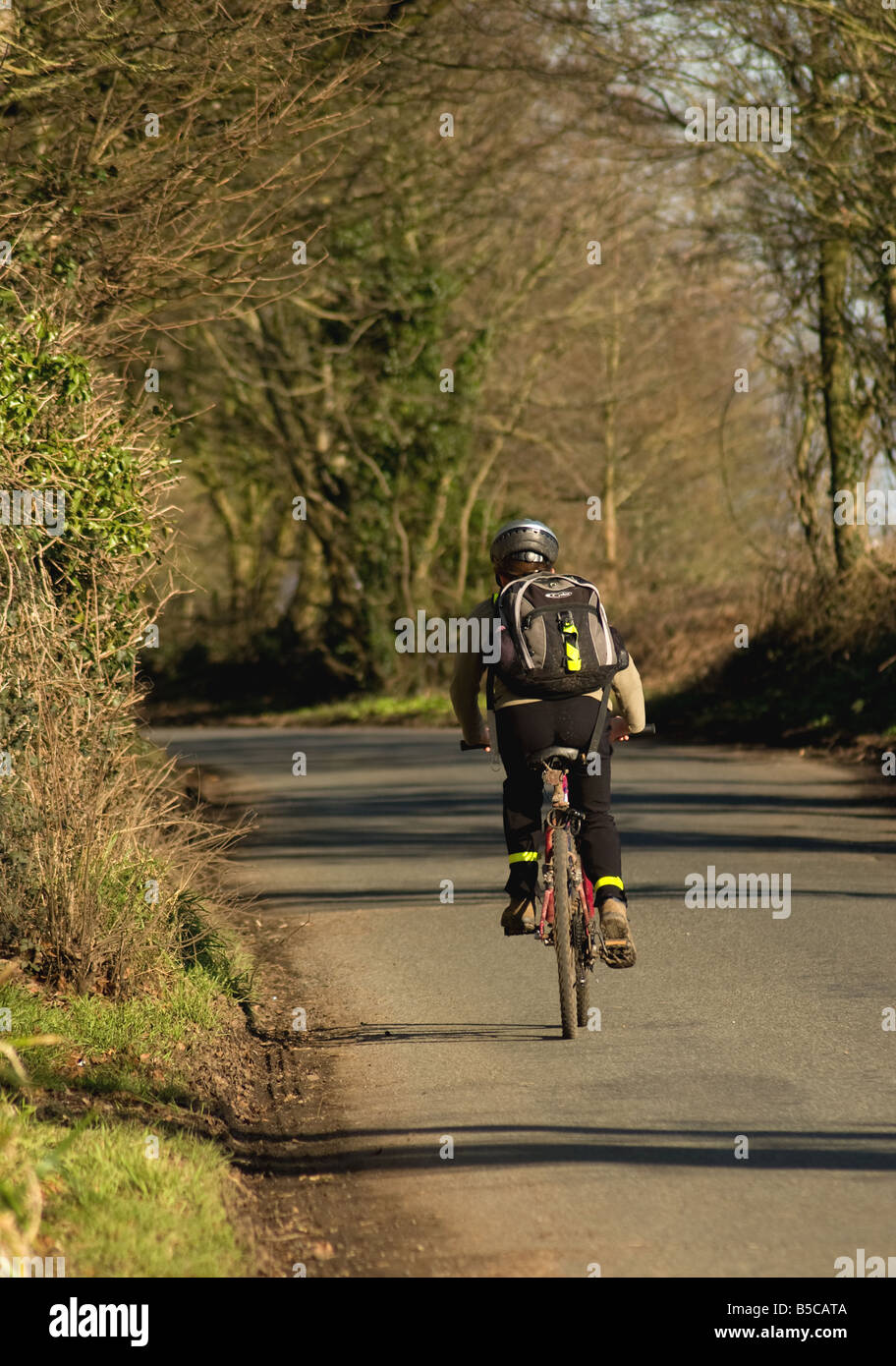 Cyclist riding along a country road Stock Photo - Alamy